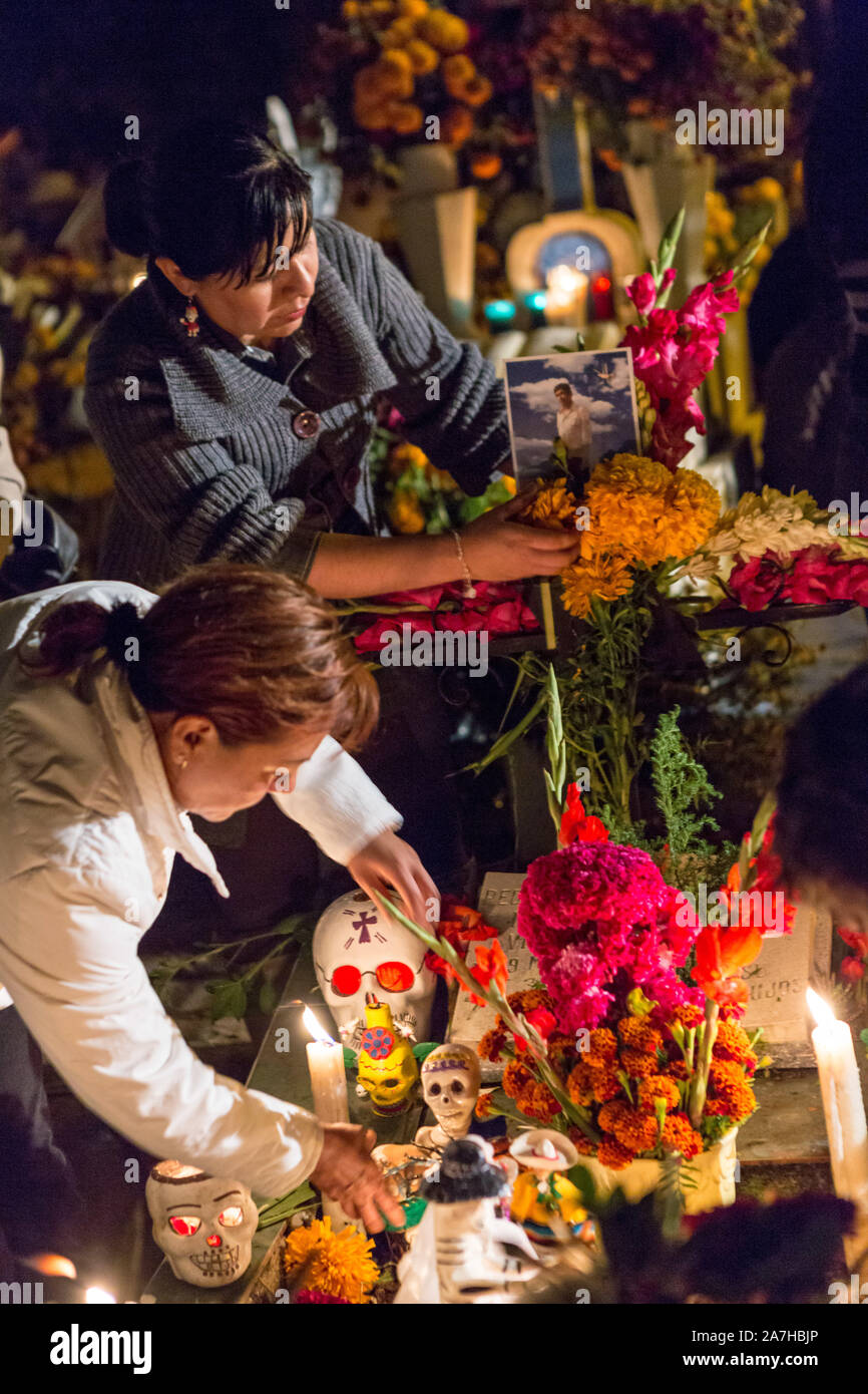 Family members light candles in honor of the dead at San Felipe de Aqua ...