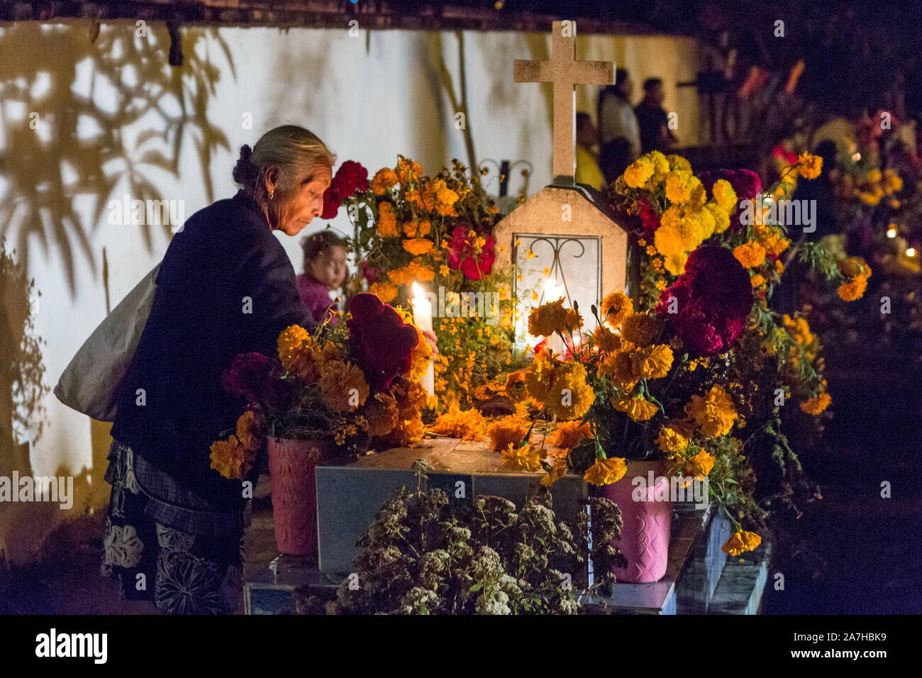 Family members light candles in honor of the dead at San Felipe de Aqua ...