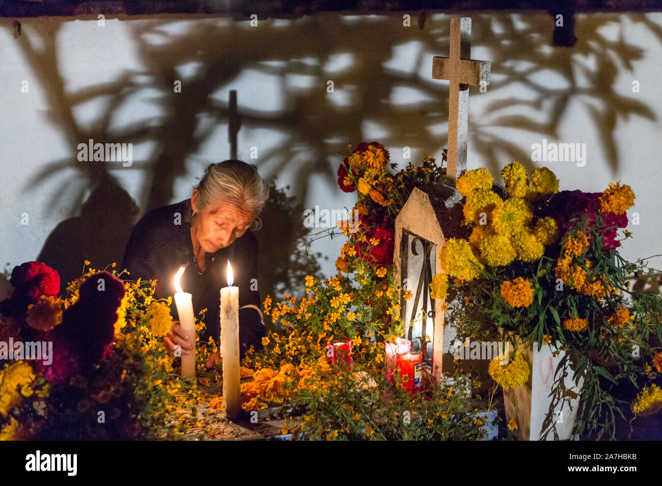 Family members light candles in honor of the dead at San Felipe de Aqua ...