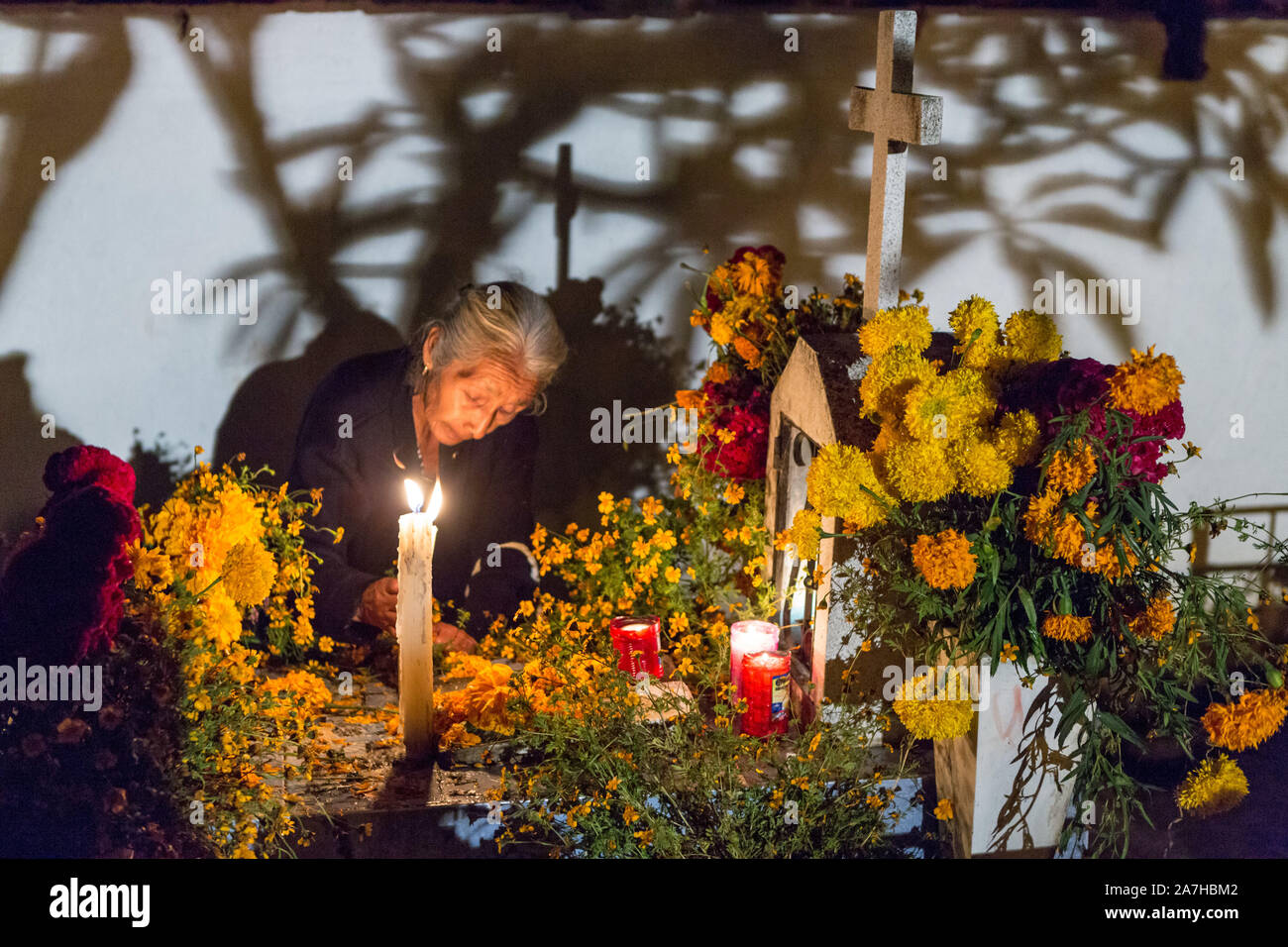 Family members light candles in honor of the dead at San Felipe de Aqua ...