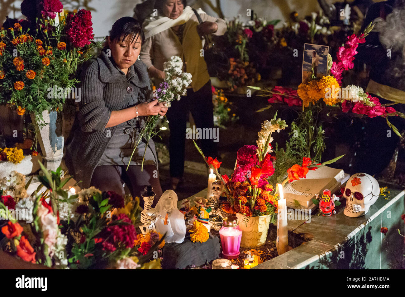Family members light candles in honor of the dead at San Felipe de Aqua ...