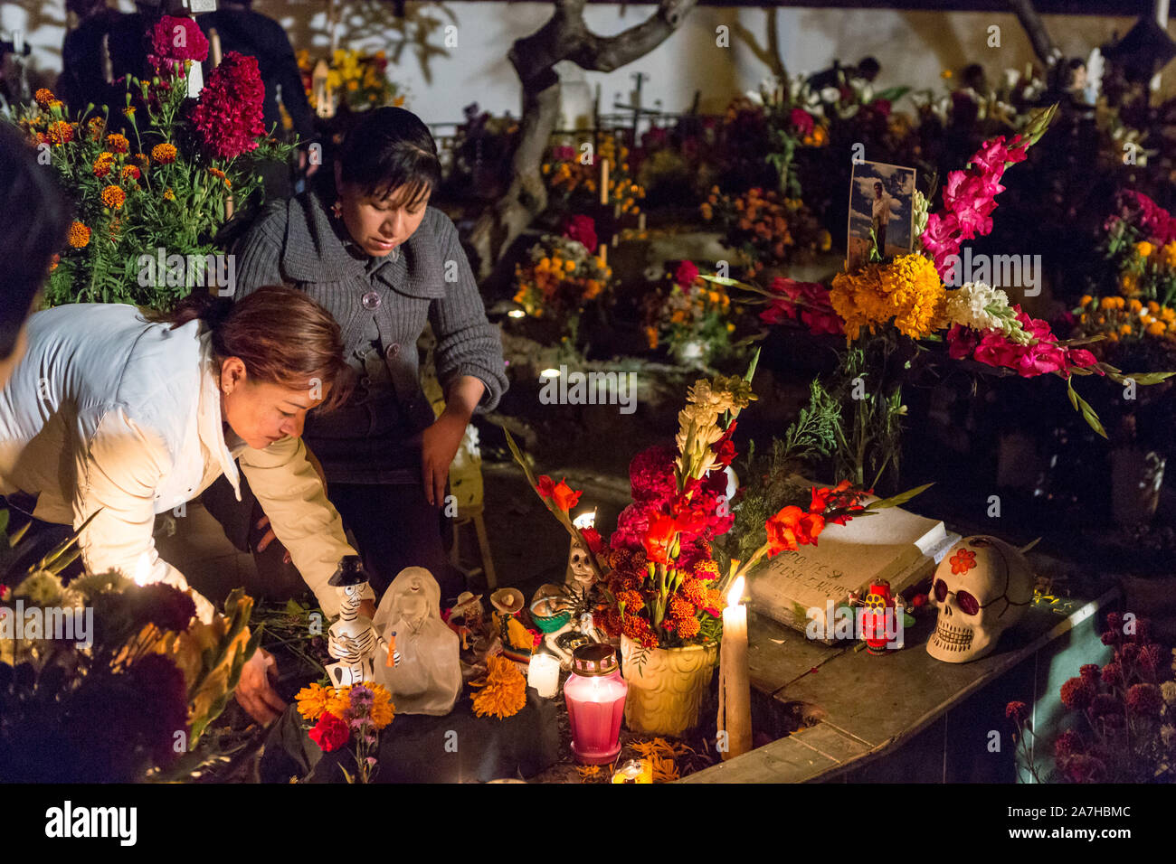 Family members light candles in honor of the dead at San Felipe de Aqua ...