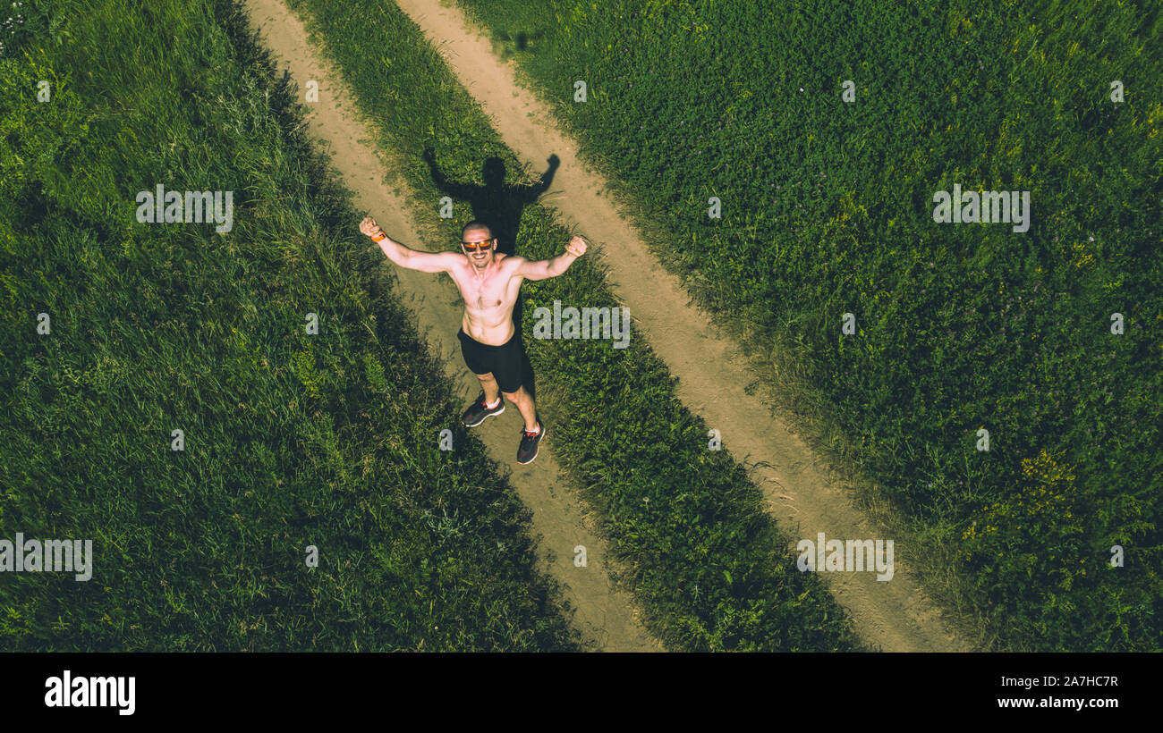 Man athlete runner with hands up standing on road Stock Photo - Alamy