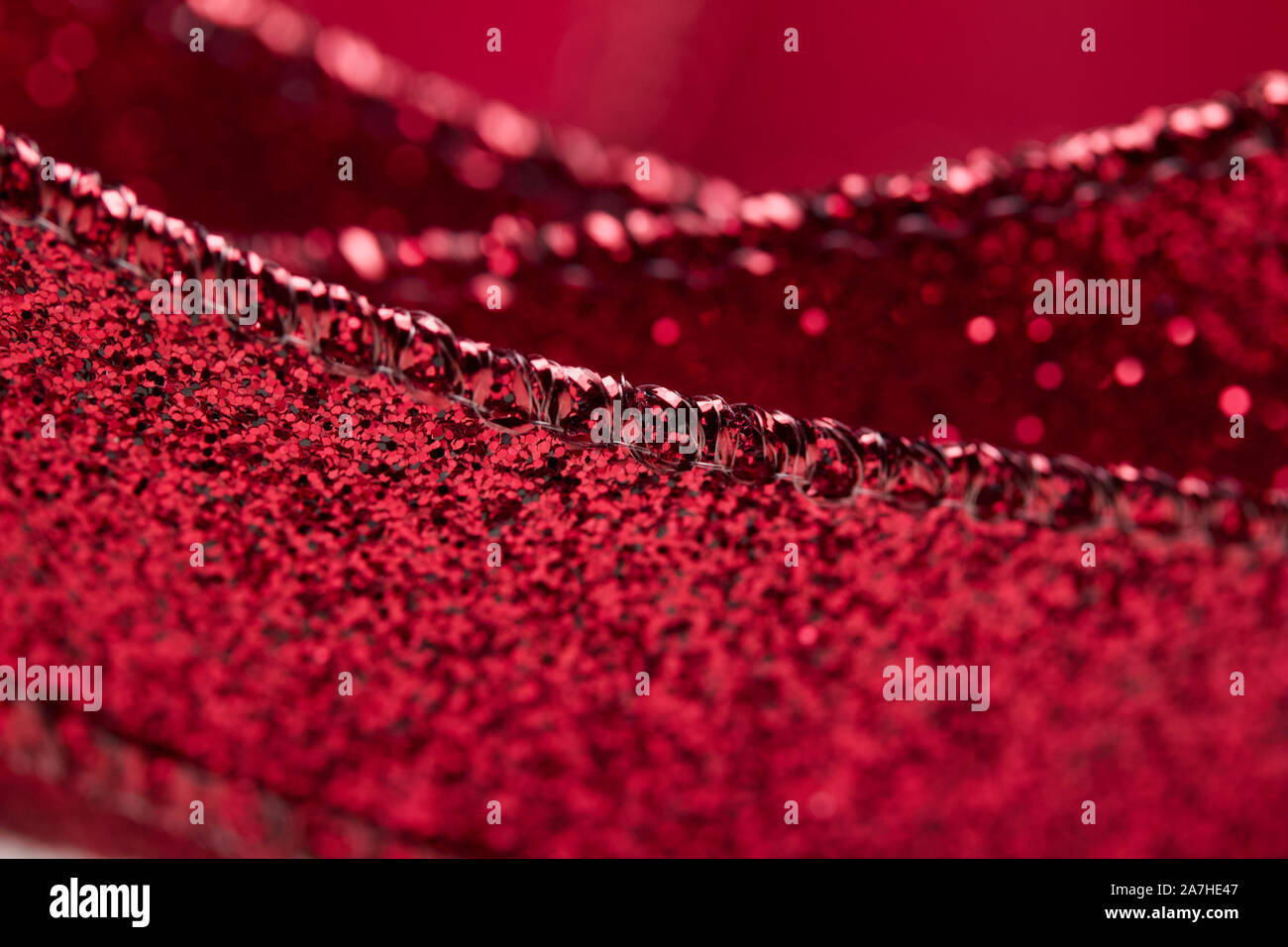 Macro background of brightly lit beautiful sparkling red glitter fabric ...