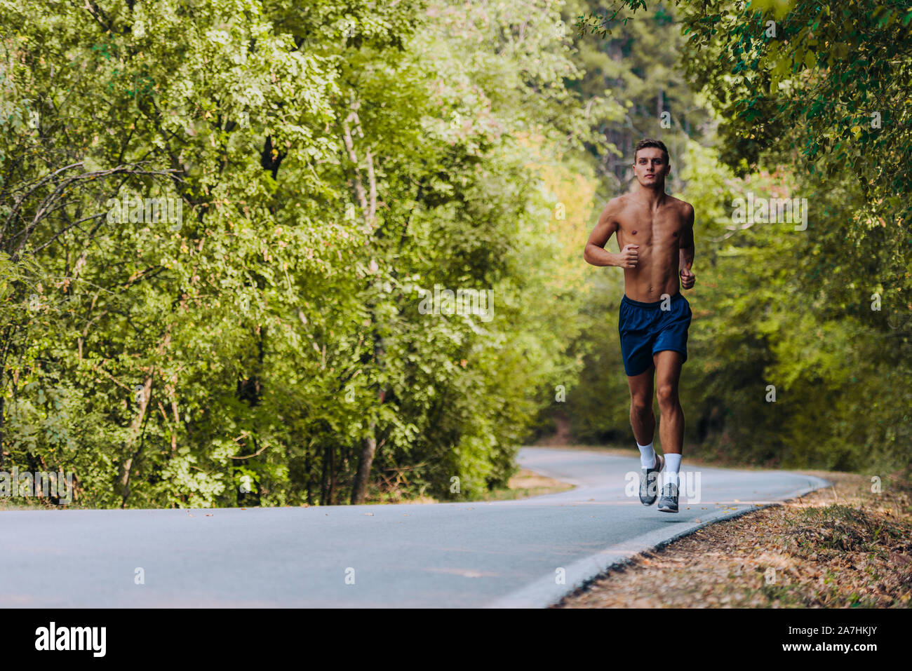 Man running on road in beautiful nature. Male runner sprinting during ...