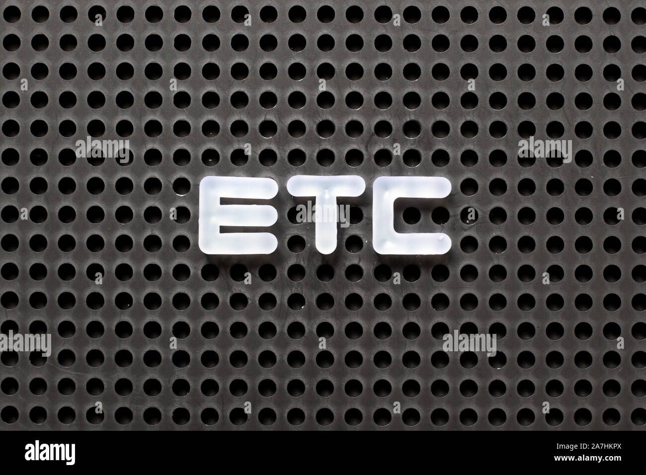 Black color pegboard with white letter in word etc (abbreviation of et ...