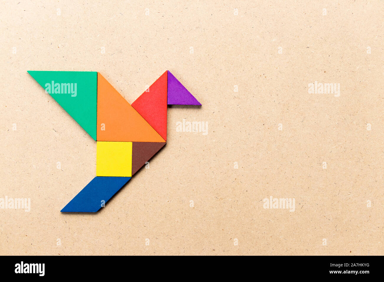Color tangram puzzle in flying bird shape on wood background Stock ...