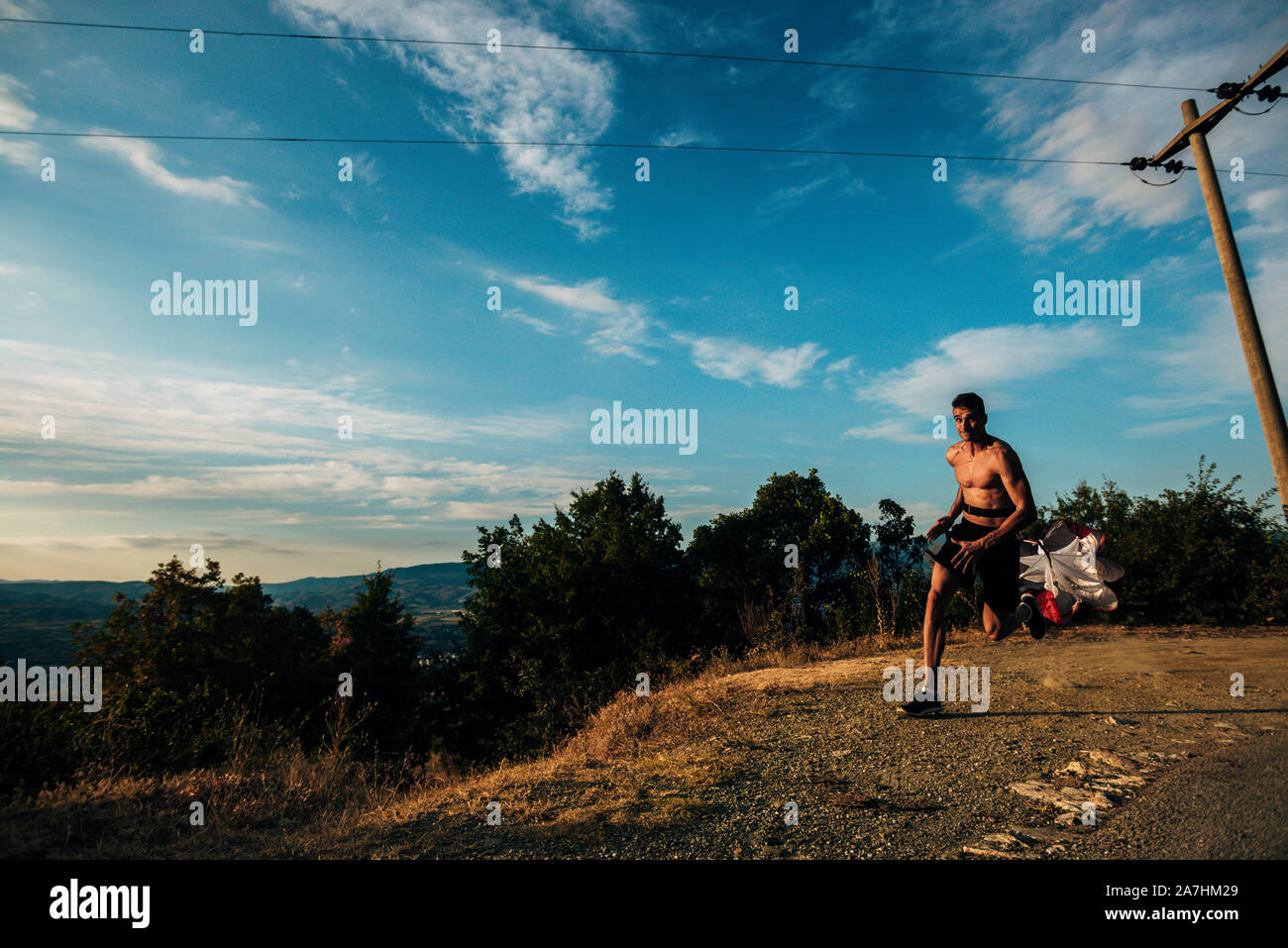 Male runner silhouette with parachute, Man running into sunset ...