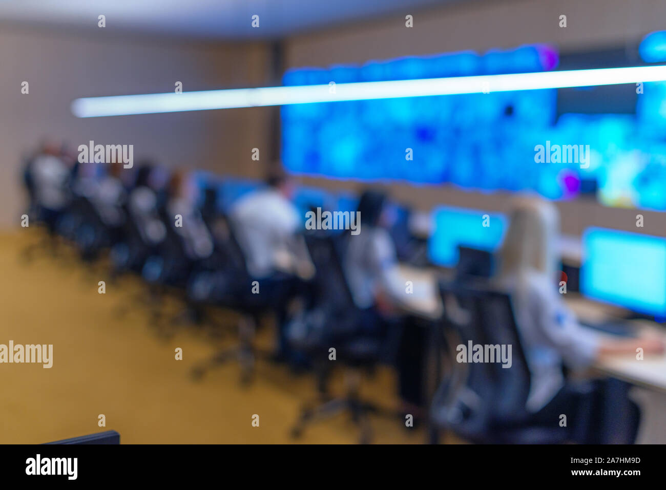 Blurred photo of security guards working on computers while sitting in ...