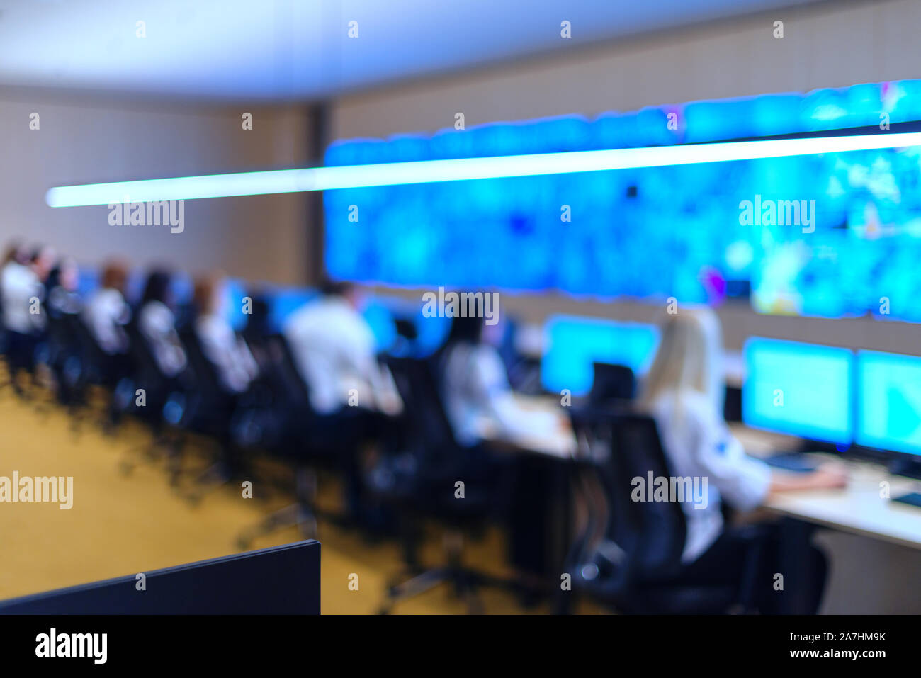 Blurred photo of security guards working on computers while sitting in ...