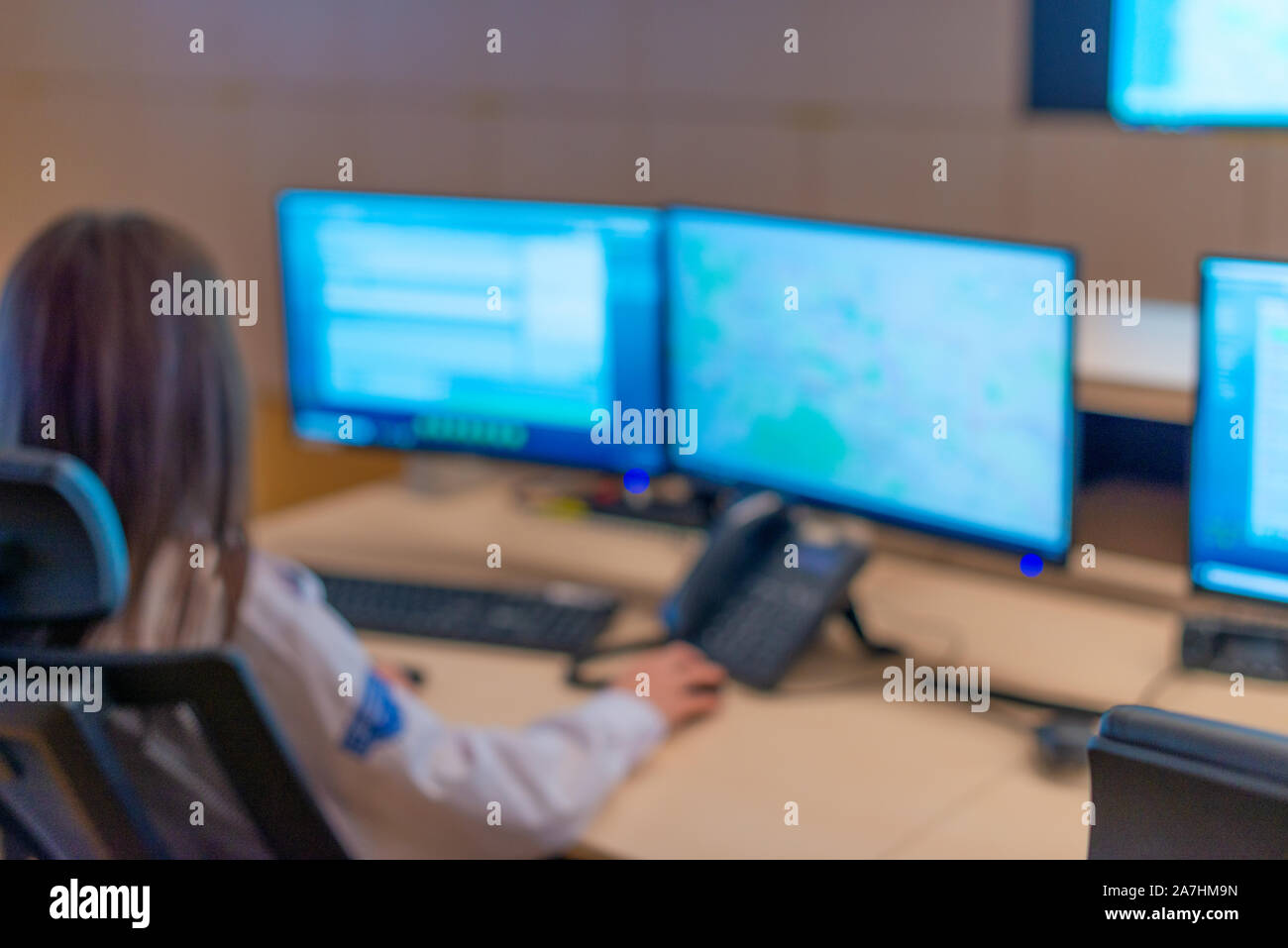 Blurred photo of security guards working on computers while sitting in ...