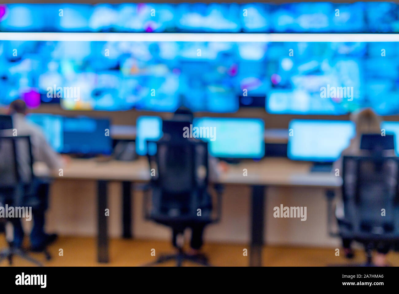 Blurred photo of security guards working on computers while sitting in ...