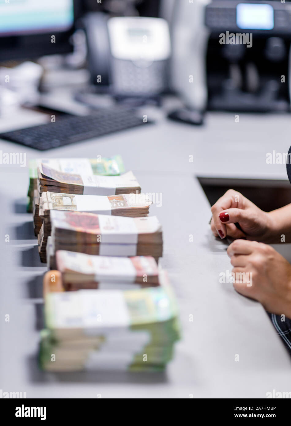 Accountant placing banknotes that are bundled with currency straps into ...