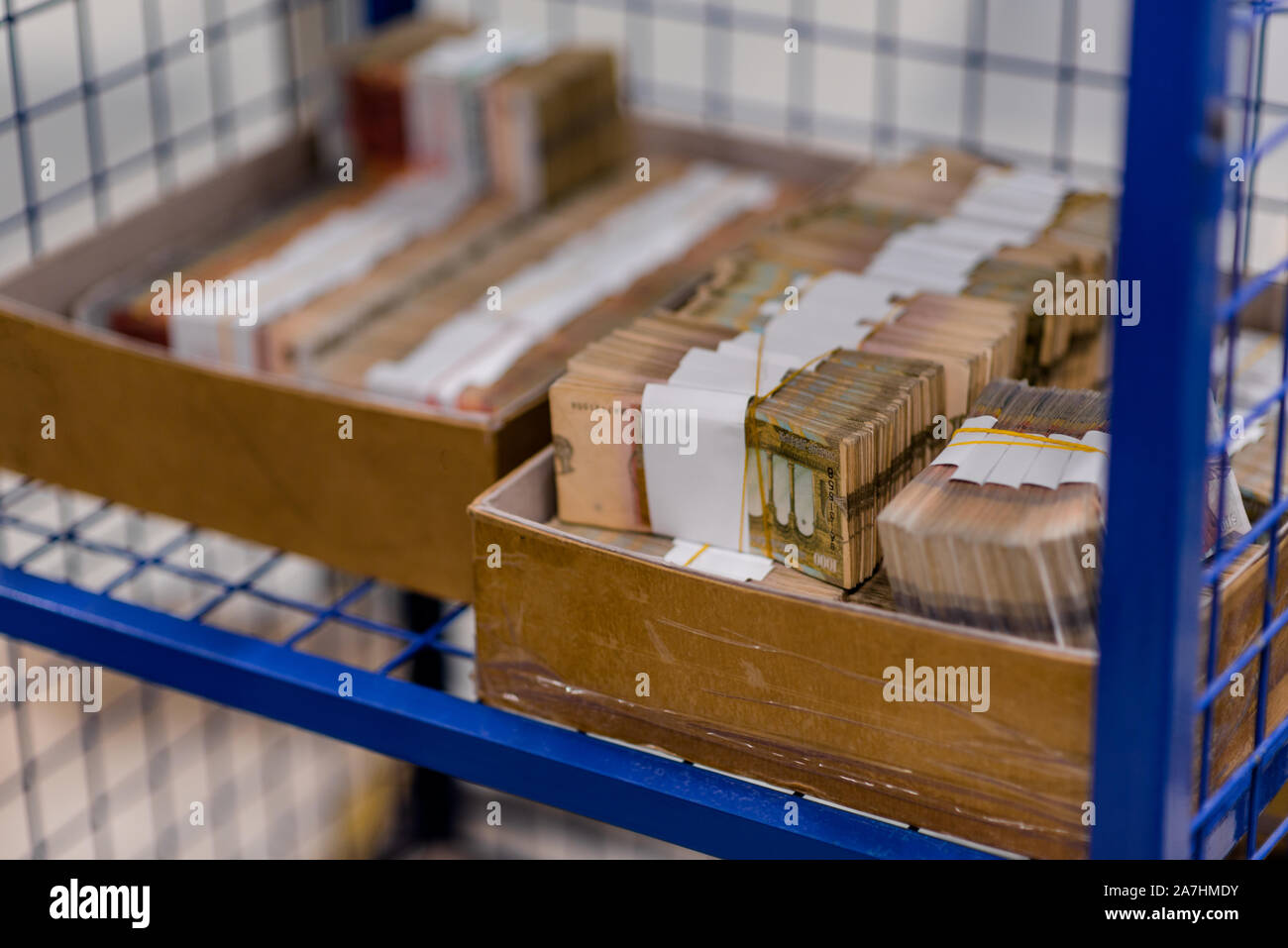 Bundles of cash with currency straps put in boxes in blue metal secured ...