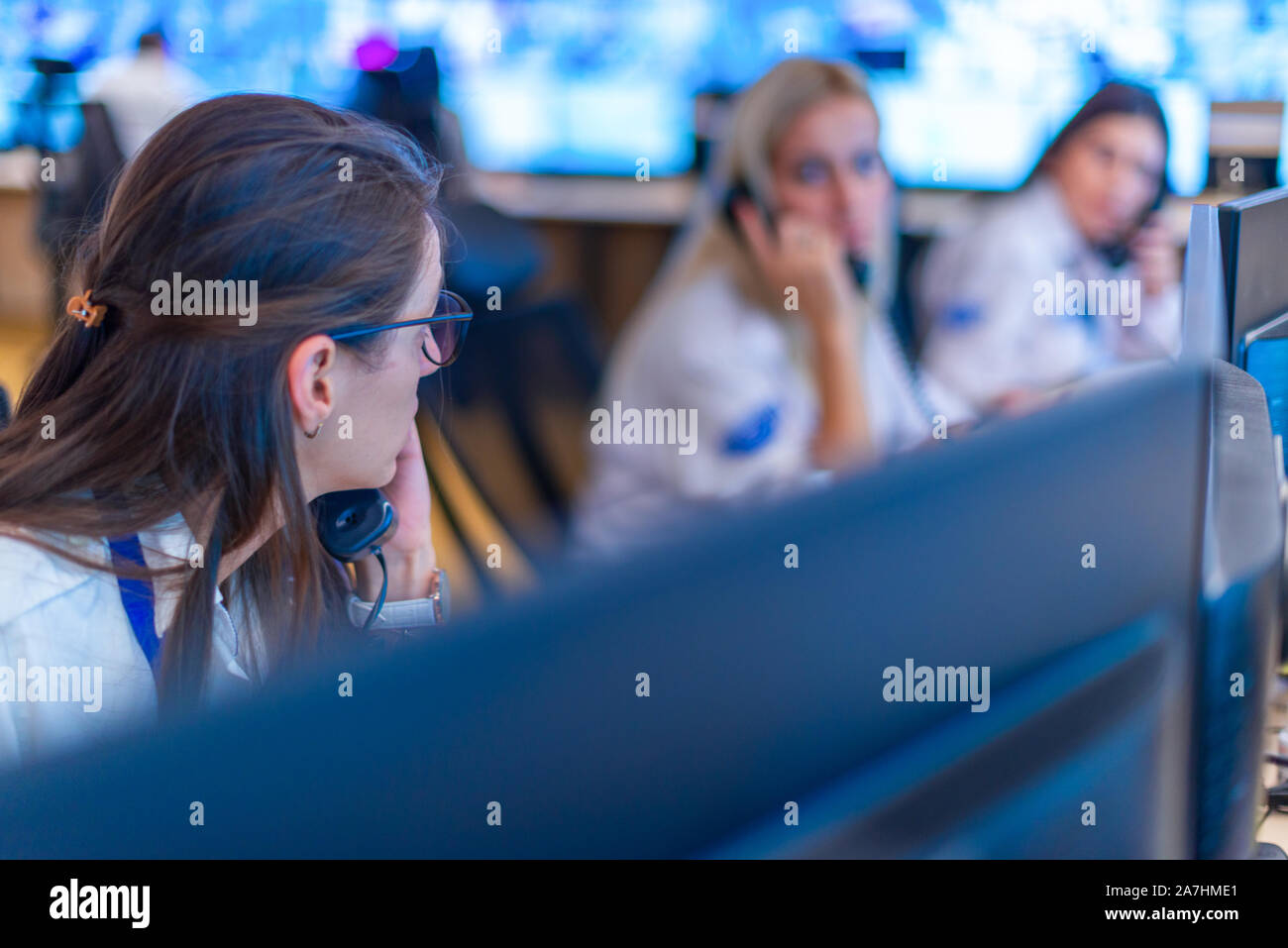Female security guard operator talking on the phone while watching the ...