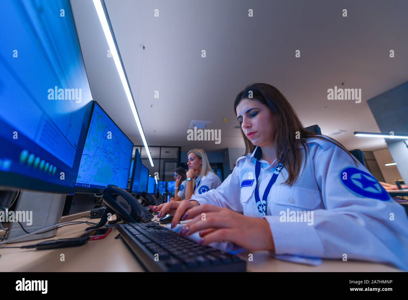 Female security operator working in a security data control room ...