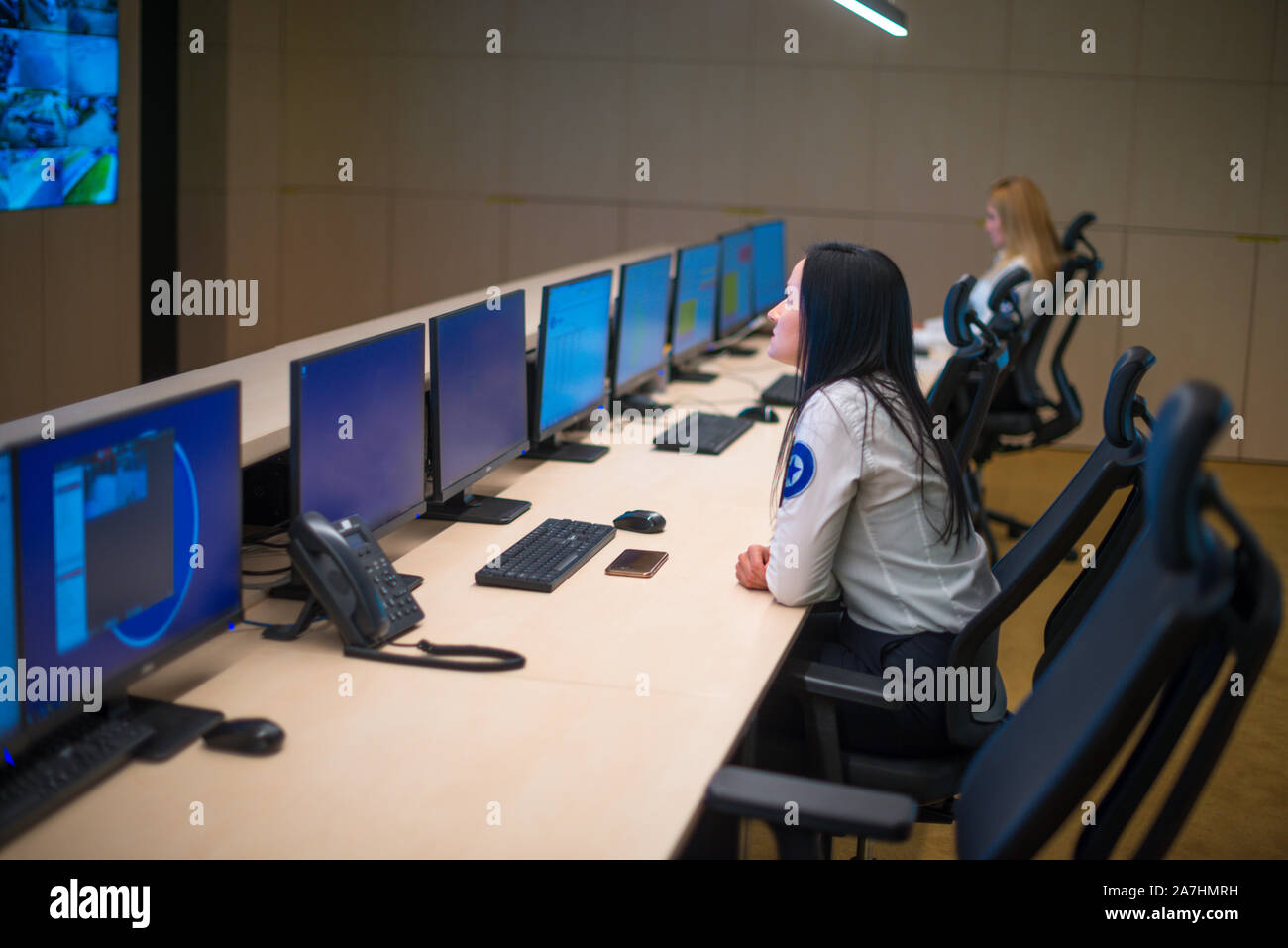 Security guard monitoring modern CCTV cameras in a surveillance room ...