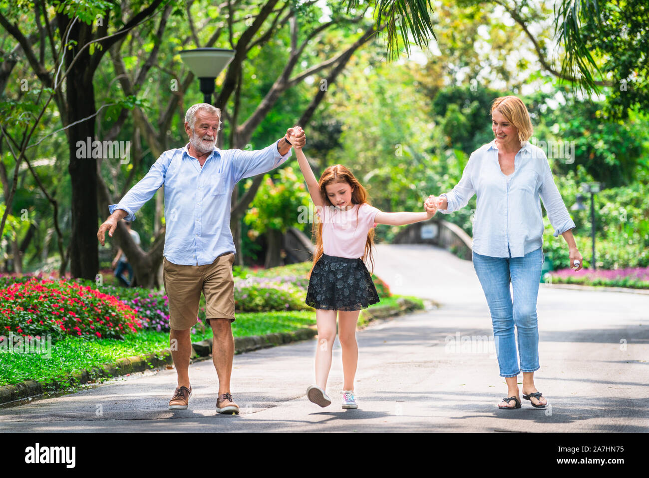 Happy healthy family walk together on path in the park in summer ...