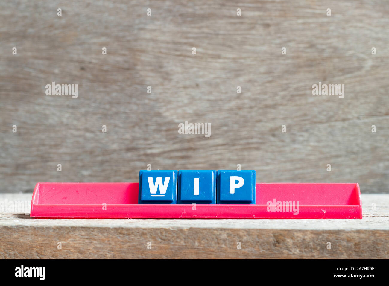 Tile letter on red rack in word WIP (Abbreviation of work in progress ...