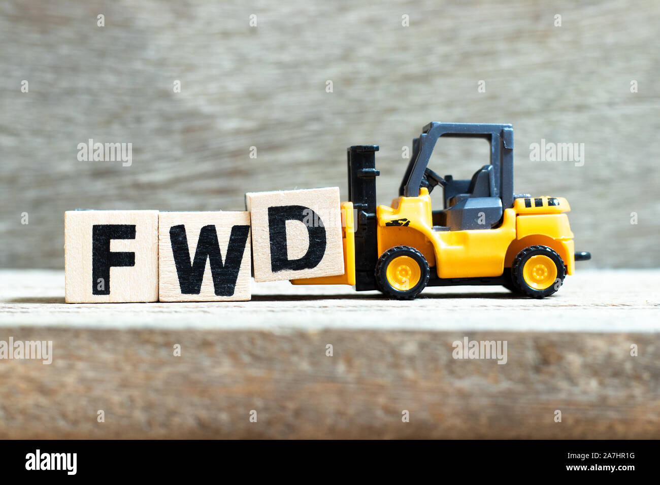 Toy forklift hold letter block D to complete word FWD (Abbreviation of ...