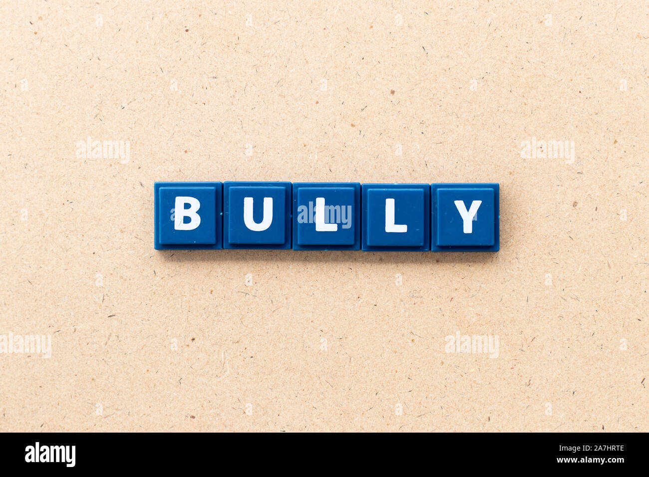 Tile letter in word bully on wood background Stock Photo - Alamy