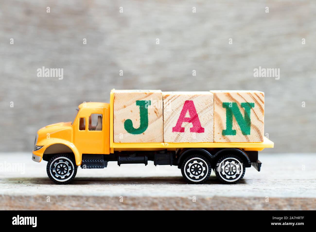 Truck hold letter block in word jan on wood background (Concept for ...