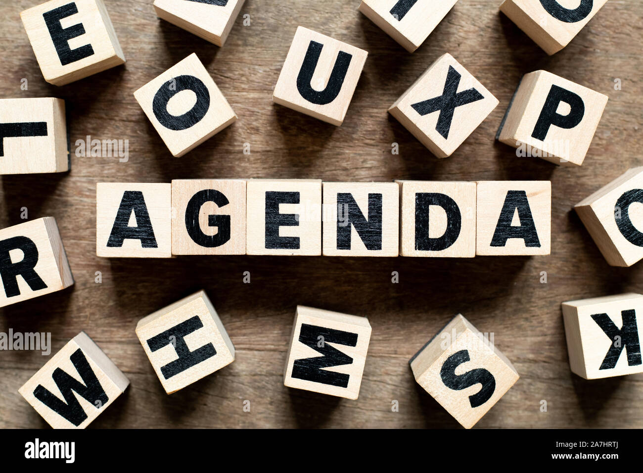 Letter block with word agenda on wood background with another alphabet ...