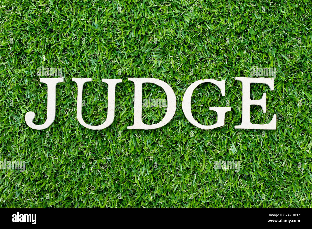 Wood alphabet letter in word judge on green grass background Stock ...