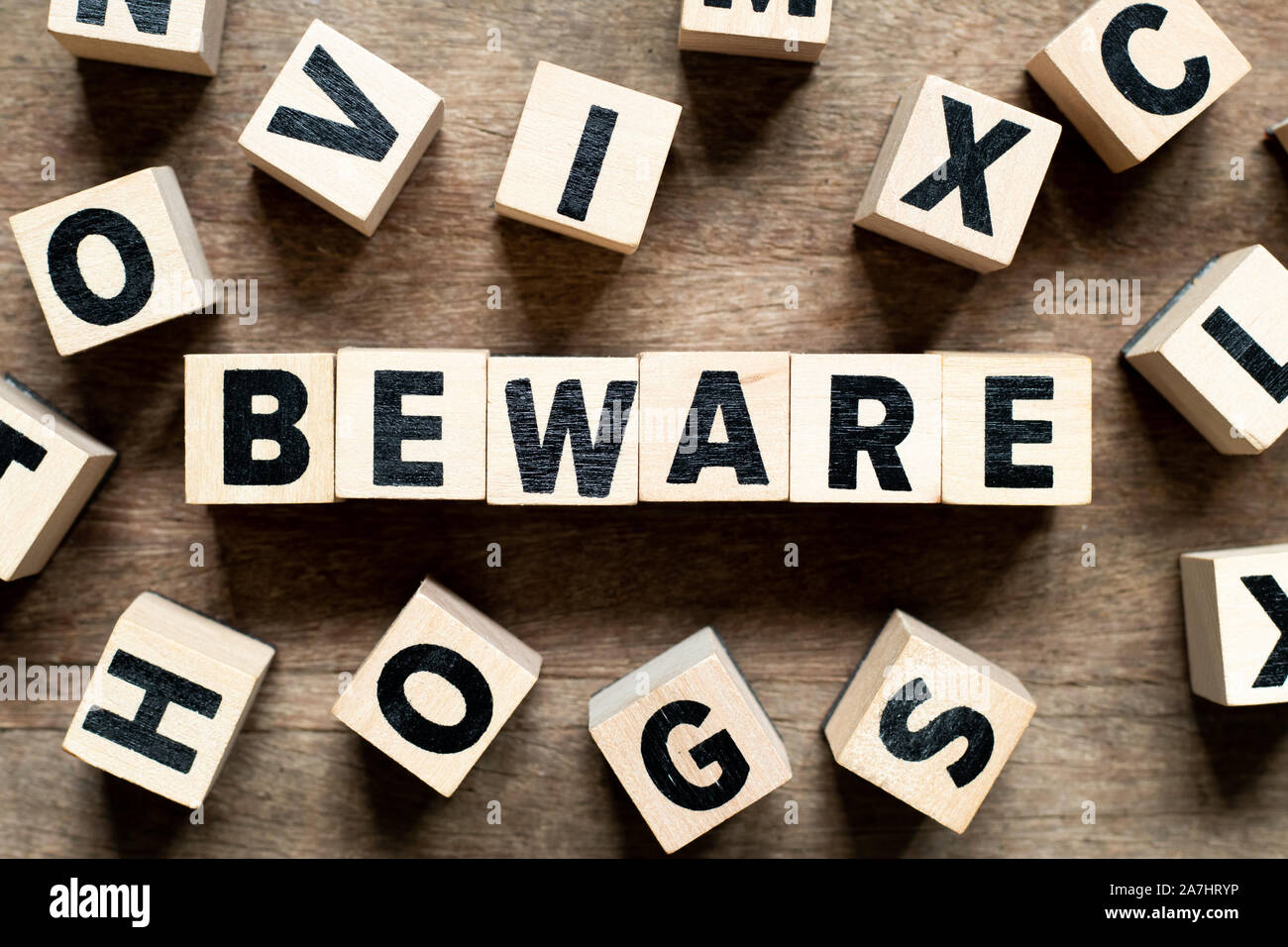 Letter block with word beware on wood background with another alphabet ...