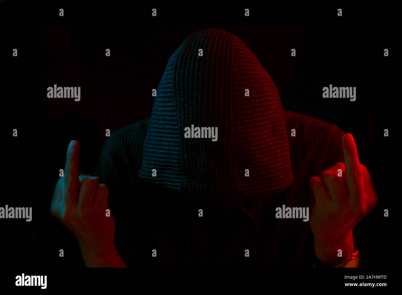 Man in a hood showing middle finger Stock Photo - Alamy