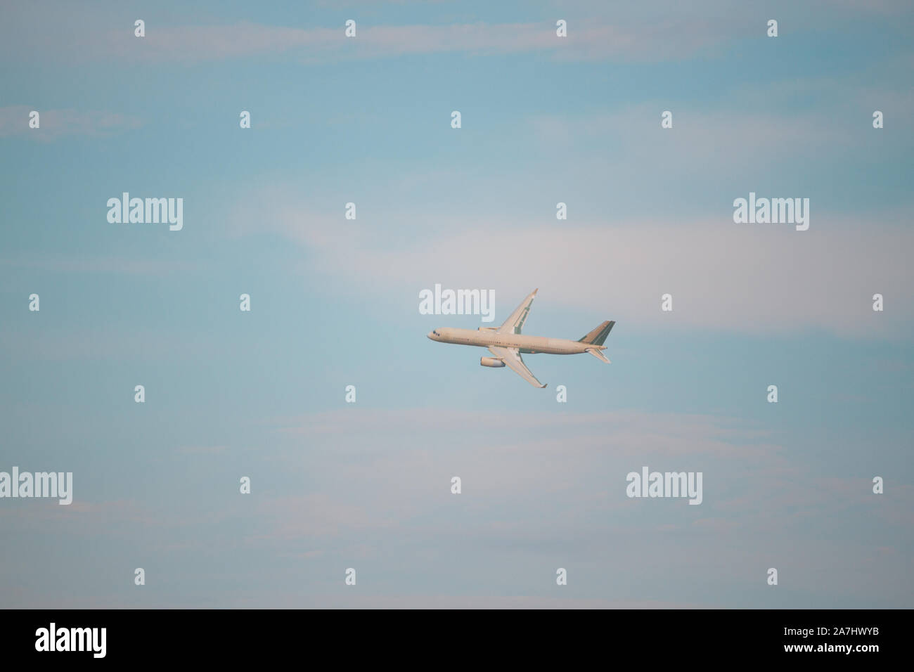 Airplane is flying in the blue sky Stock Photo - Alamy