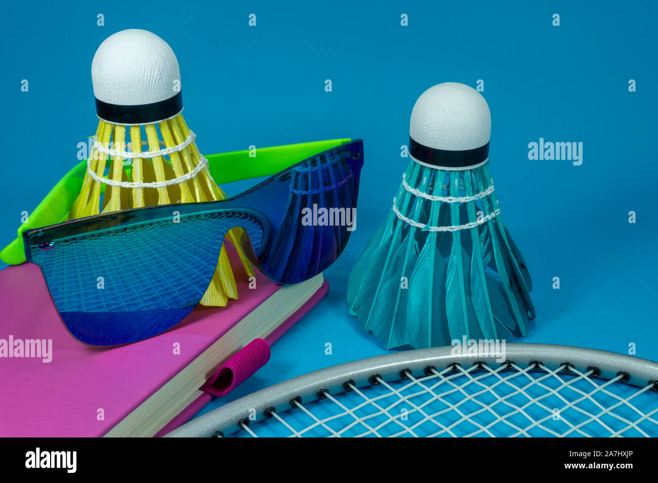 Colorful badminton shuttlecocks with racket and sunglasses resting on a ...