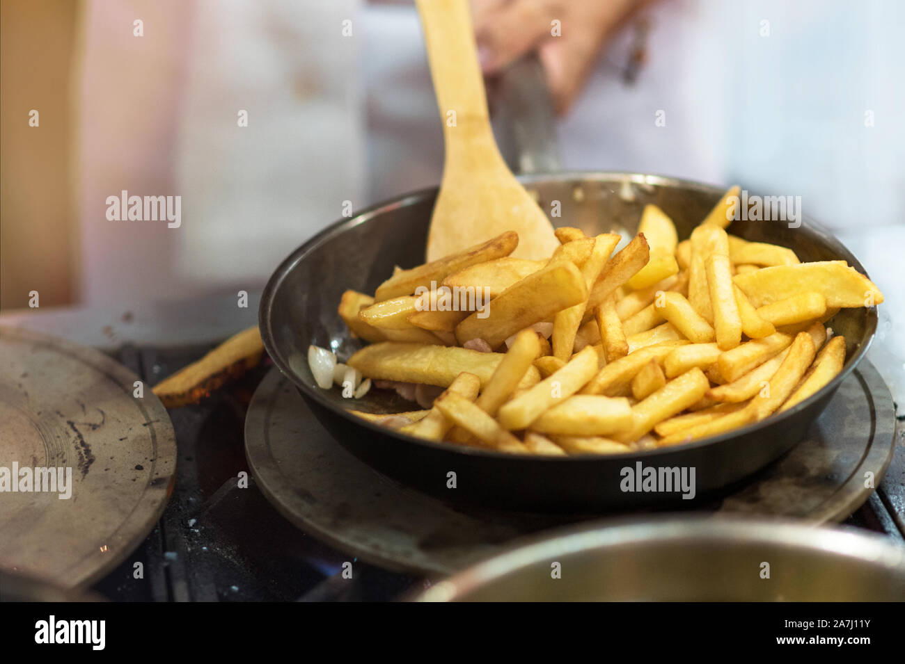 Chef is cooking french fries in the kitchen, cook preparing delicious ...