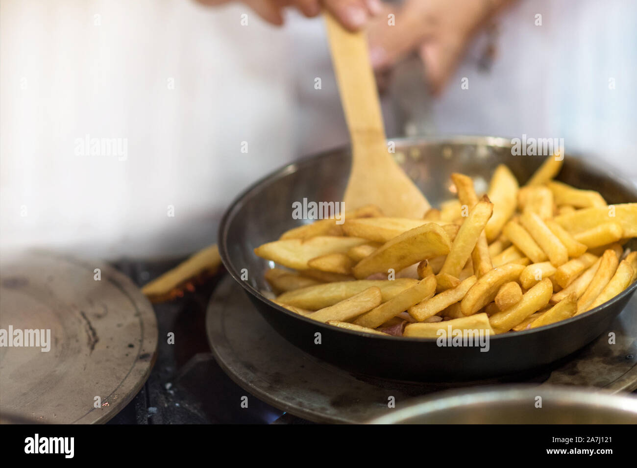 Chef is cooking french fries in the kitchen, cook preparing delicious ...