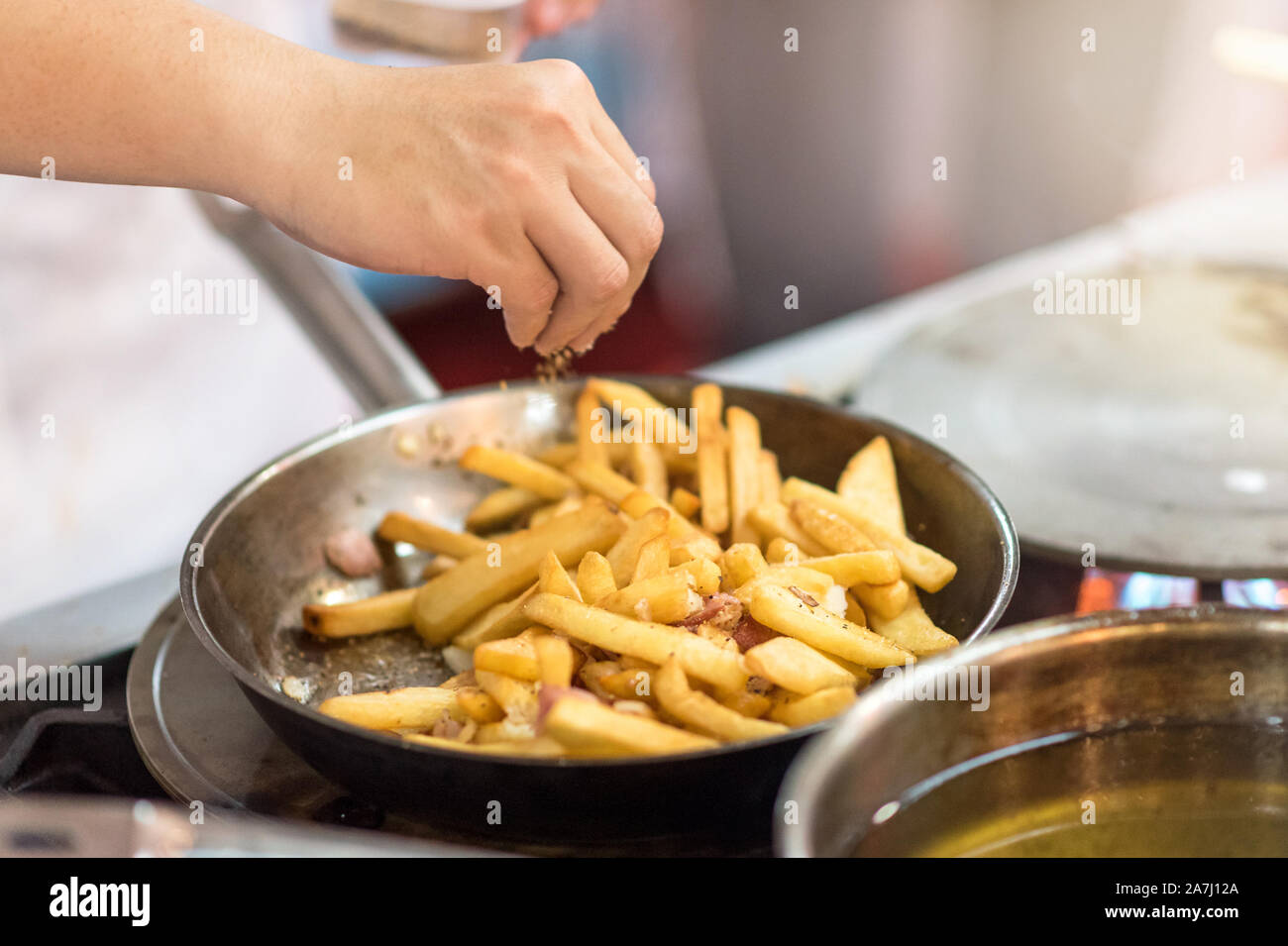 Chef is cooking french fries in the kitchen, cook preparing delicious ...
