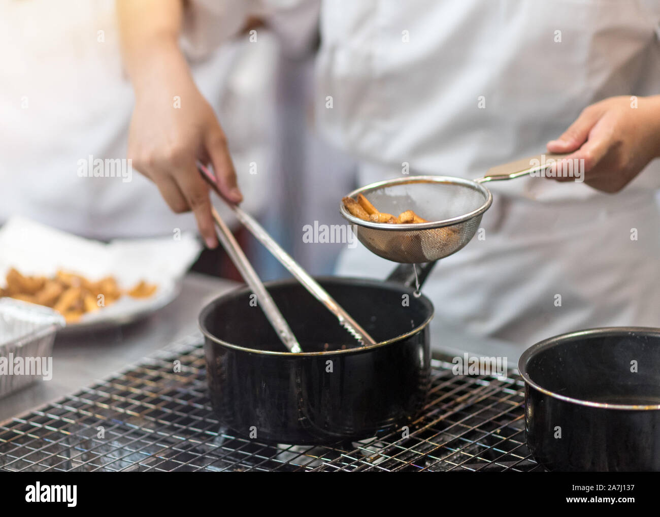 Chef is cooking french fries in the kitchen, cook preparing delicious ...