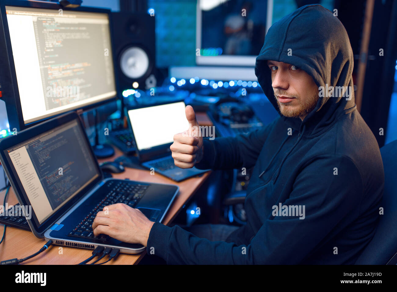 Hacker in hood shows thumbs up, network criminal Stock Photo - Alamy