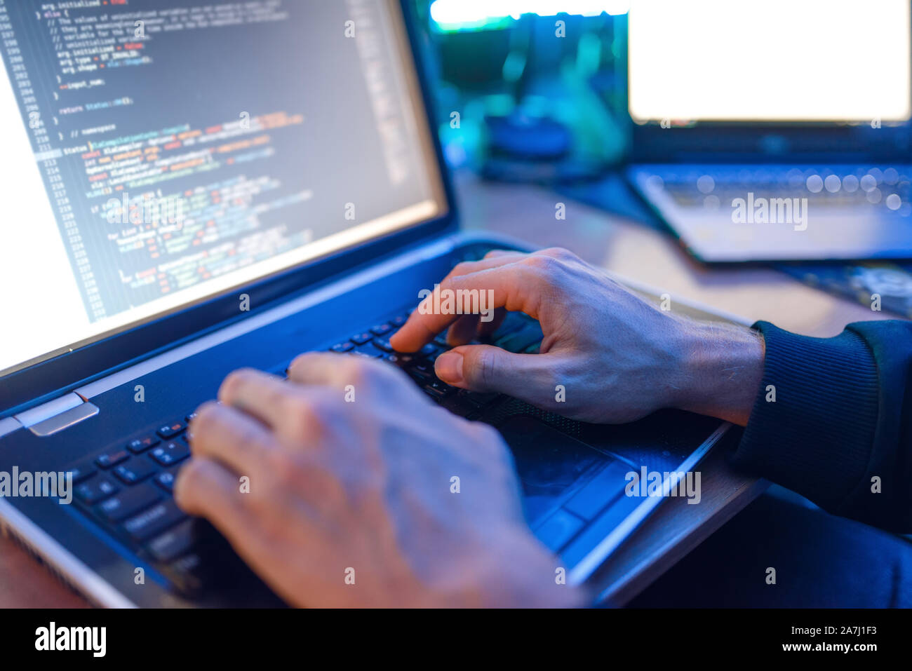Hacker sitting at laptop, information hacking Stock Photo - Alamy