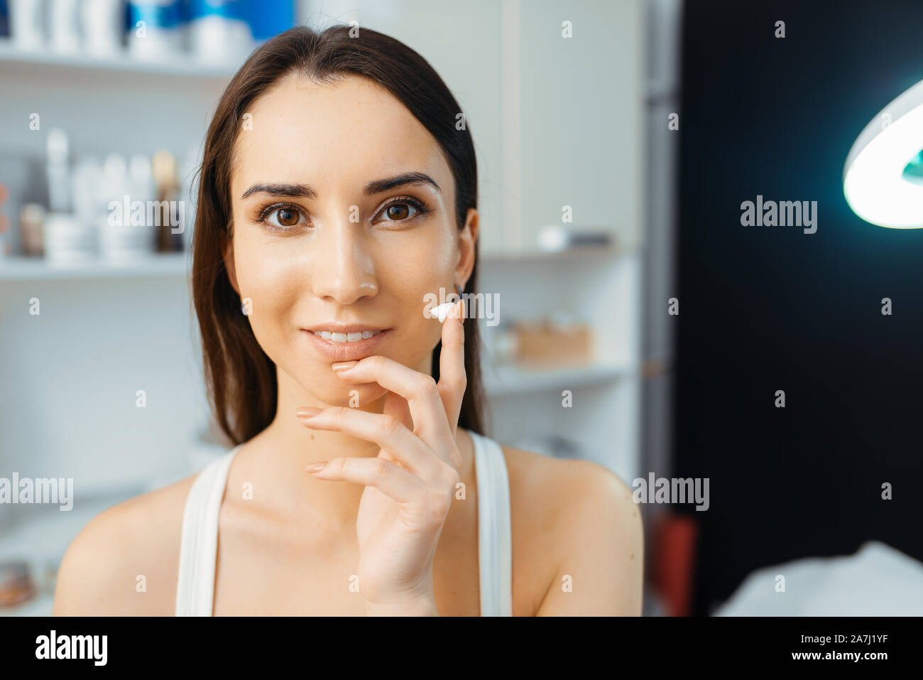 Patient shows cream on finger, cosmetician office Stock Photo - Alamy