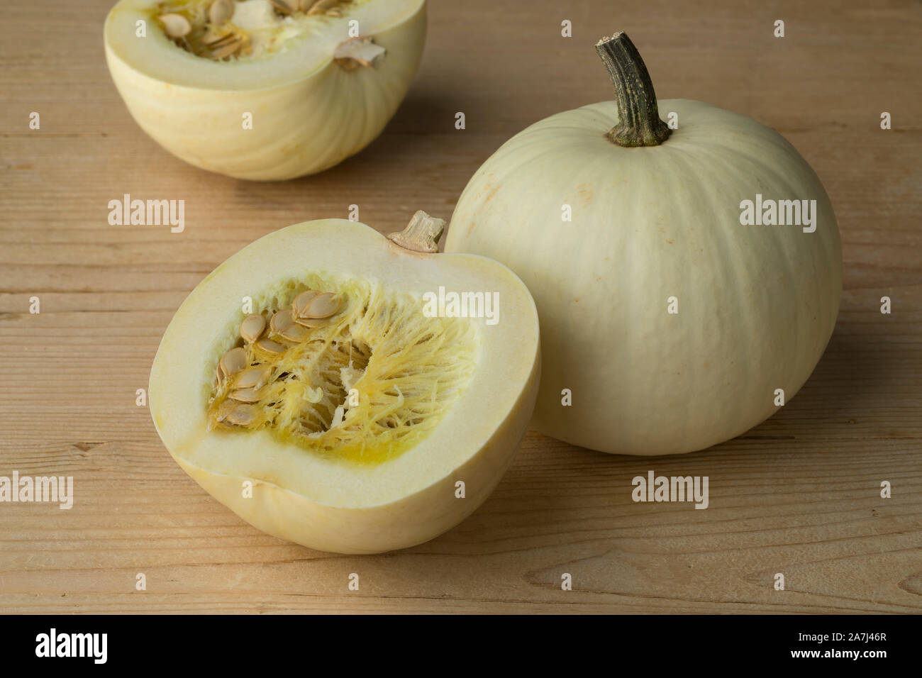 Whole and halved fresh white Lumina pumpkins with seeds Stock Photo - Alamy