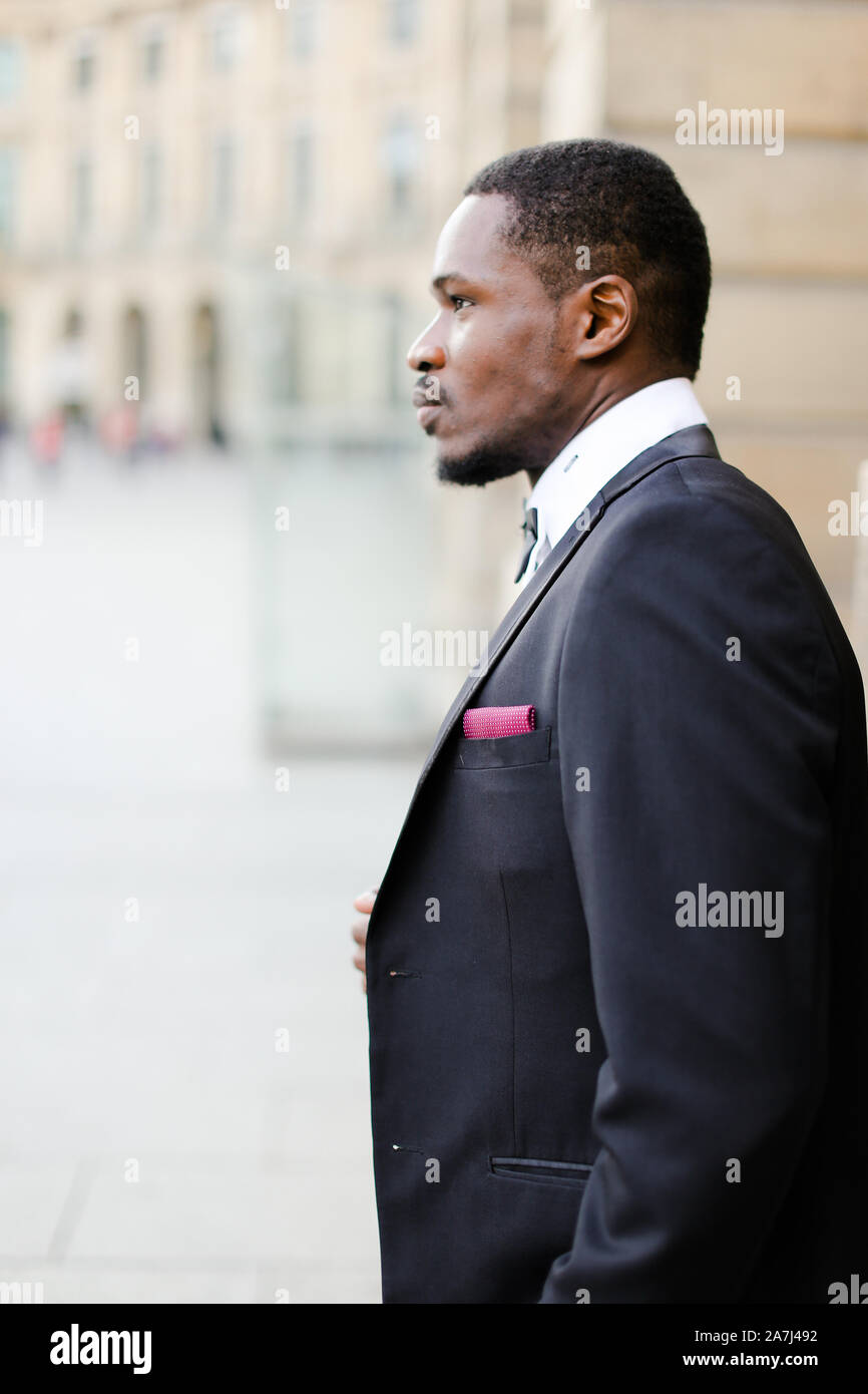 Portrait of afro american happy man wearing dark suit and standing near ...