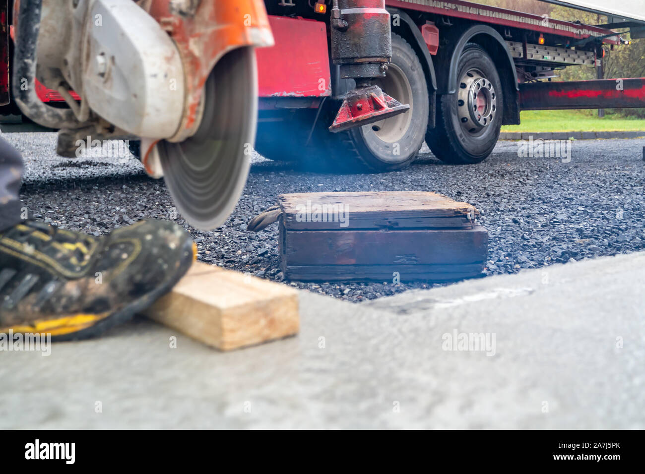 Construction worker at stone cutting work at concrete base by cut-off ...