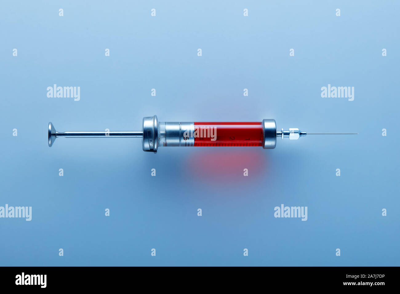 Vintage syringe filled with blood on blue background. Overhead view ...