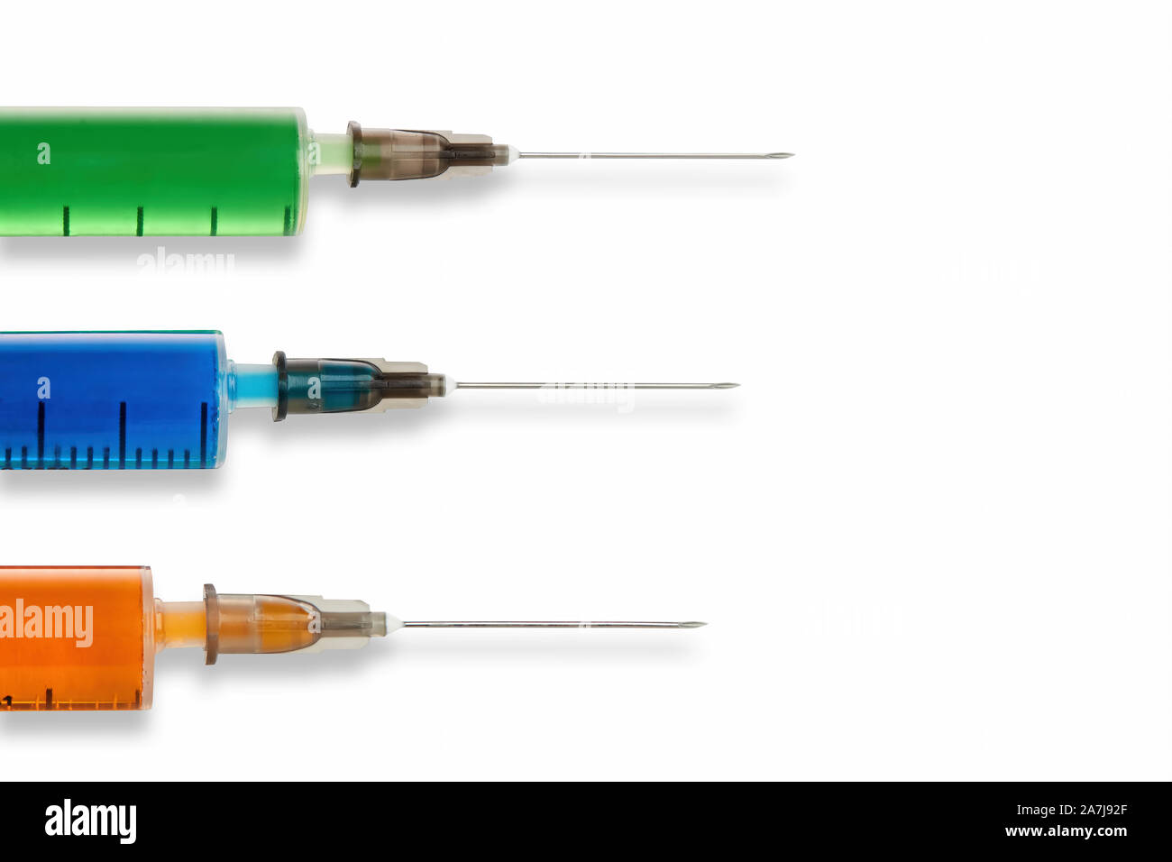 Three syringes filled with colorful liquids on isolated white ...