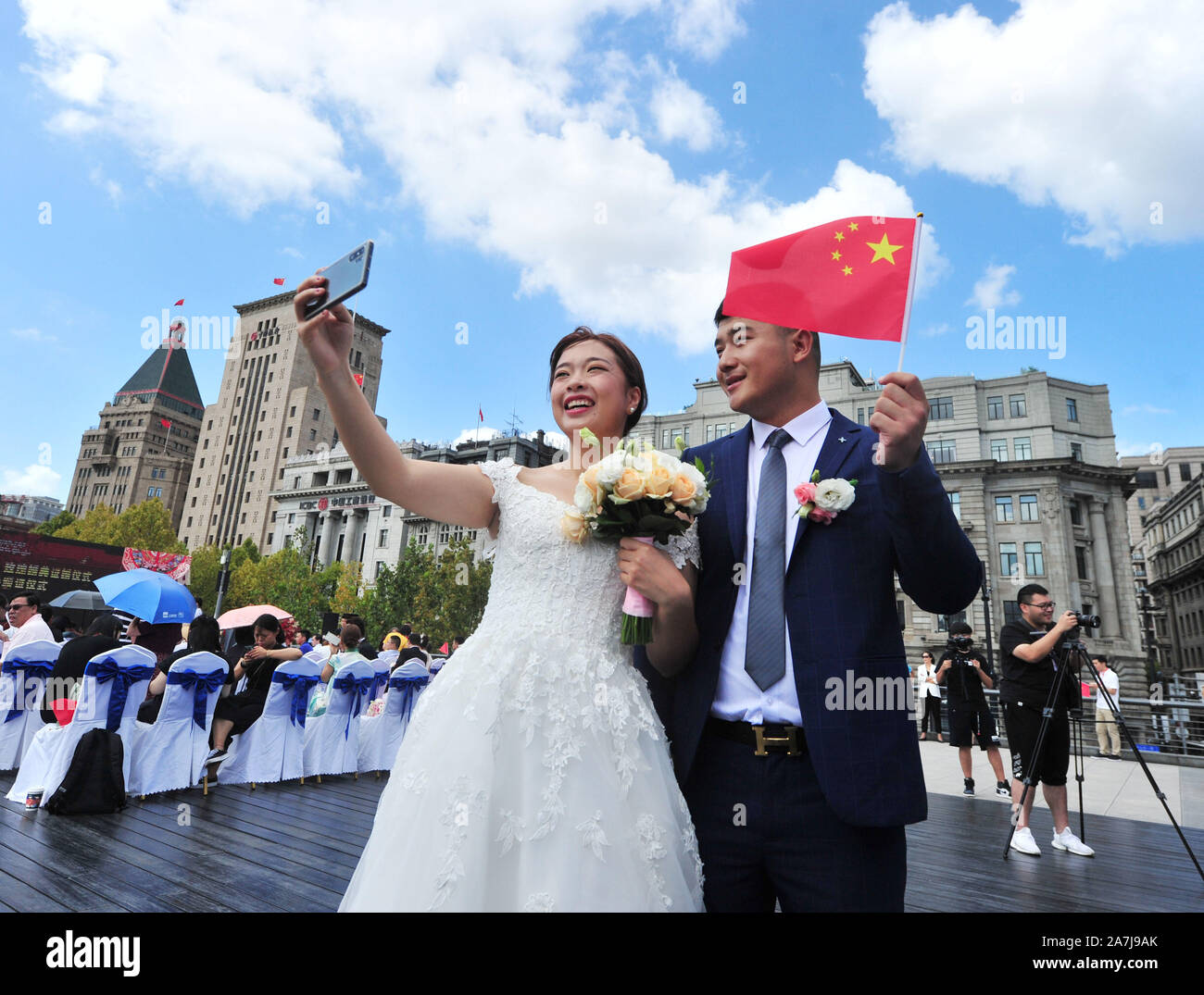 A couple take pictures of themselves by the Huangpu river in Shanghai ...