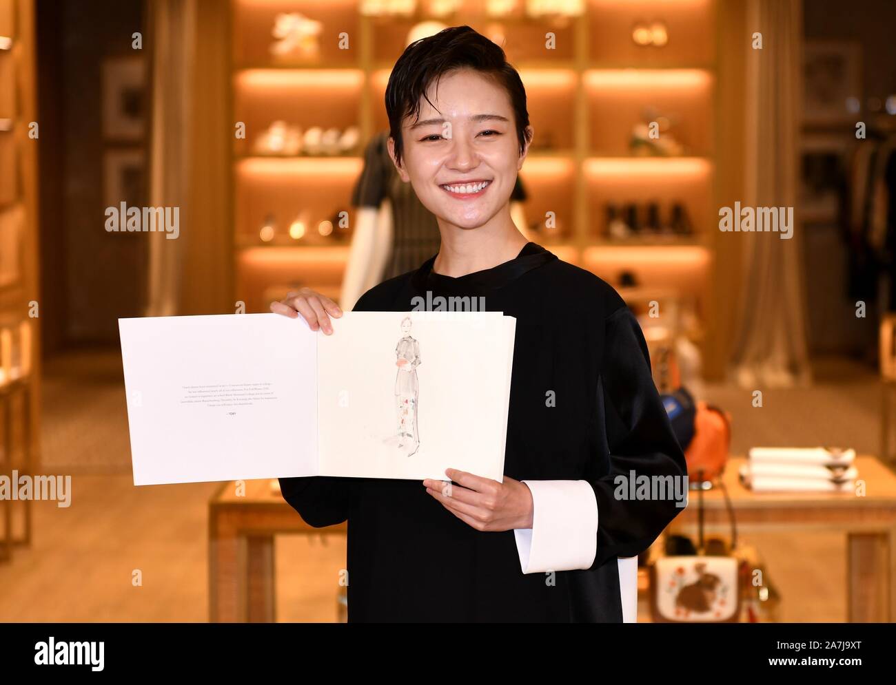 Chinese actress Jiao Junyan holds a Tory Burch album in front of the ...