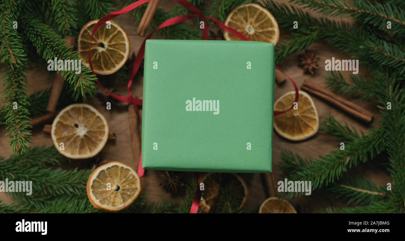 Top view man untied red ribbon bow on gift box on decorated oak table ...