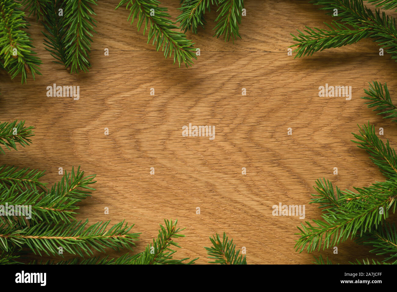 Flat lay christmas background with spruce twigs on oak wood surface ...