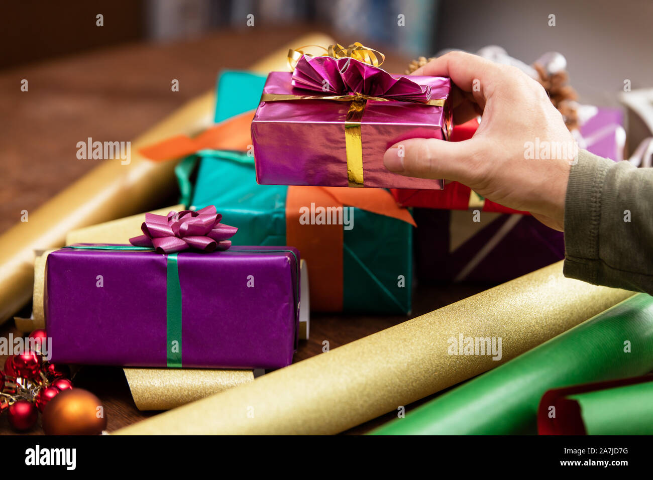 man wraps gifts for christmas or a birthday party Stock Photo - Alamy