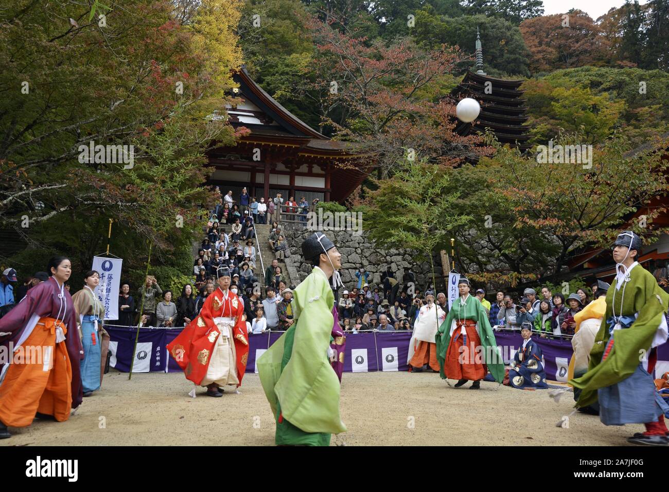 People wearing traditional Japanese costumes try to keep a ball in the ...